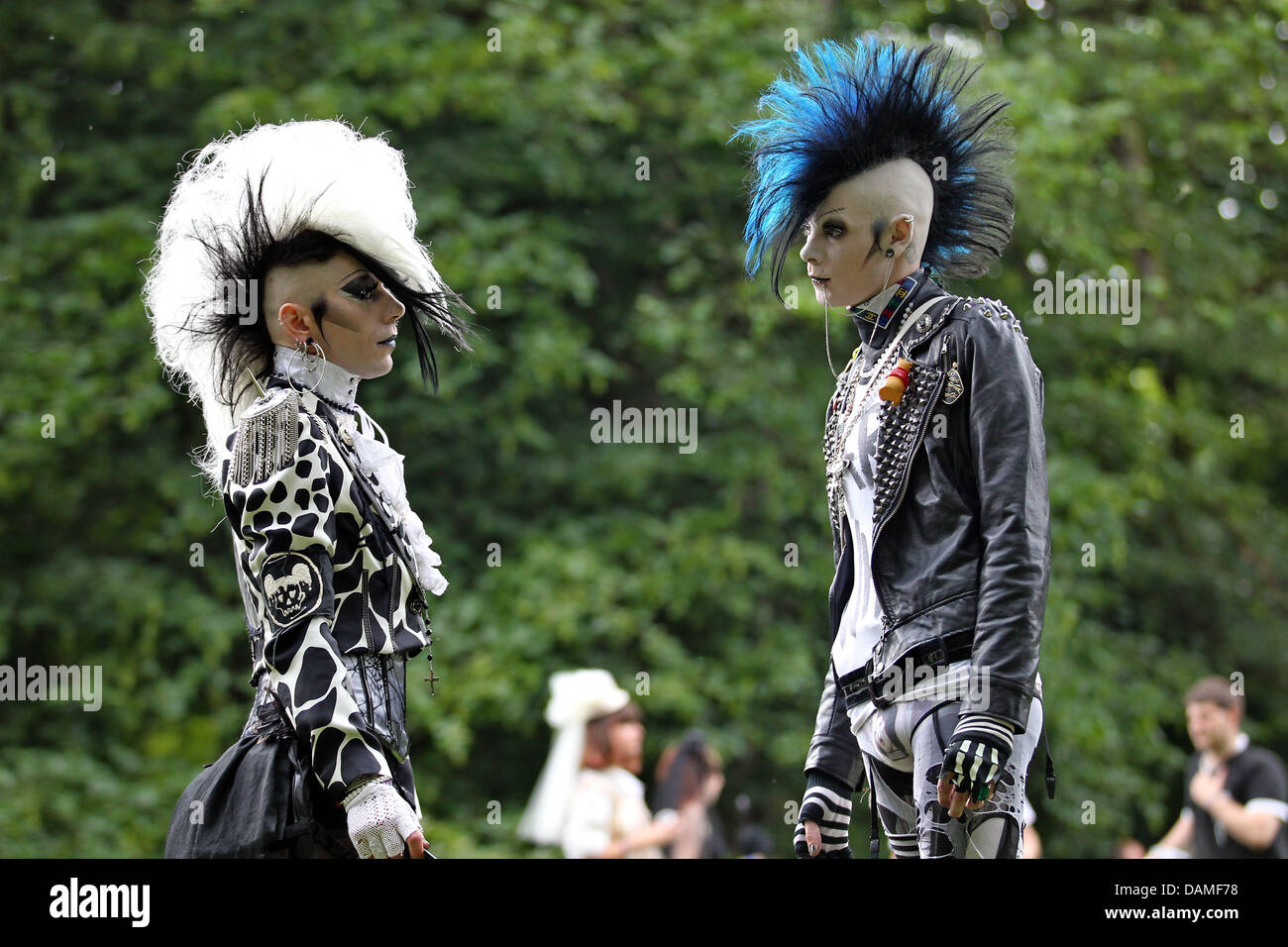 Two visitors to the Wave-Gotik-Treffen festival stand in a park in ...