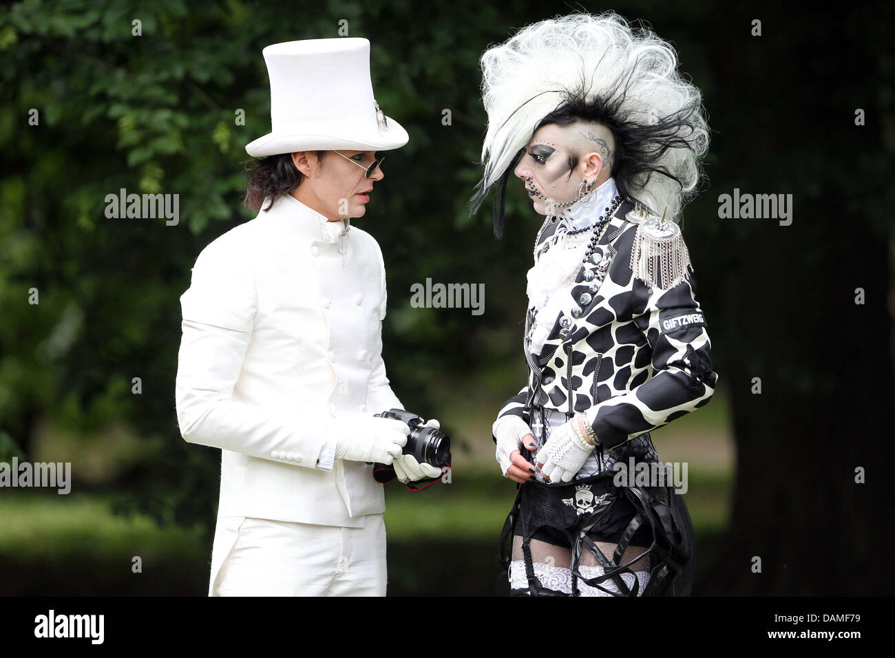 Two visitors to the Wave-Gotik-Treffen festival stand in a park in ...