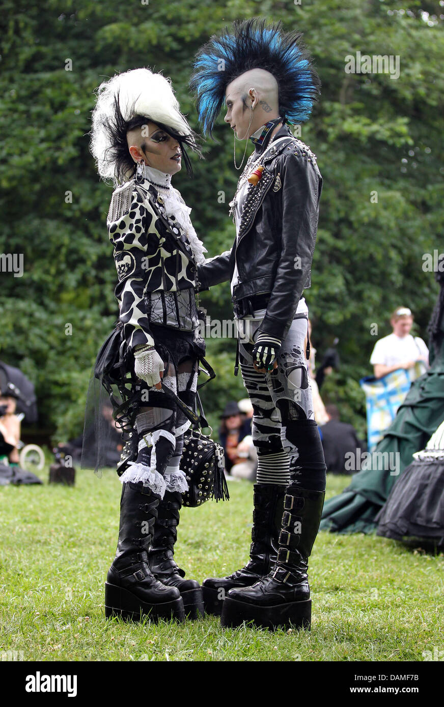 Two visitors to the Wave-Gotik-Treffen festival stand in a park in ...