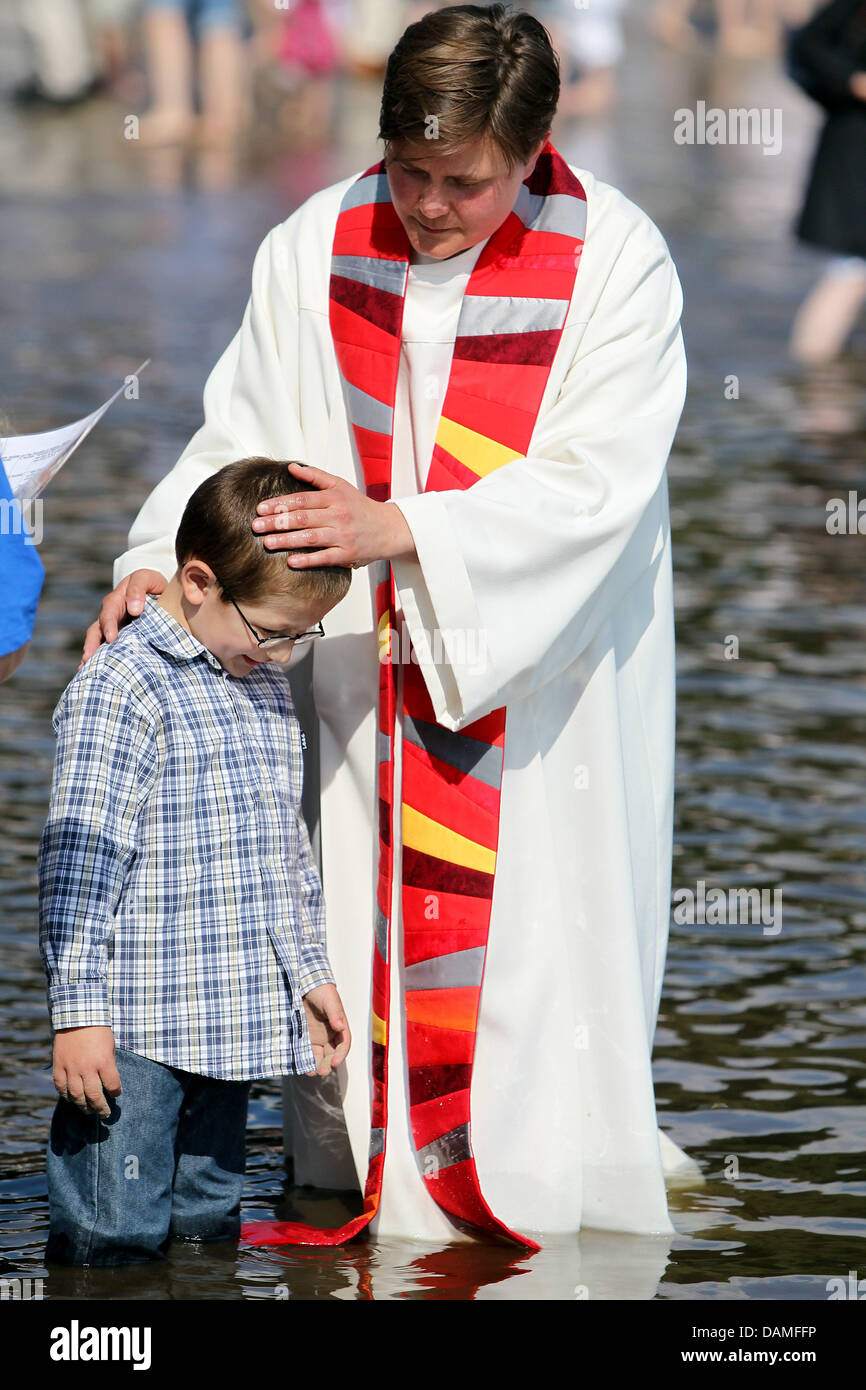 Pastor Raczek (R) baptises Jeason Mickael Berger during a mass baptism ...