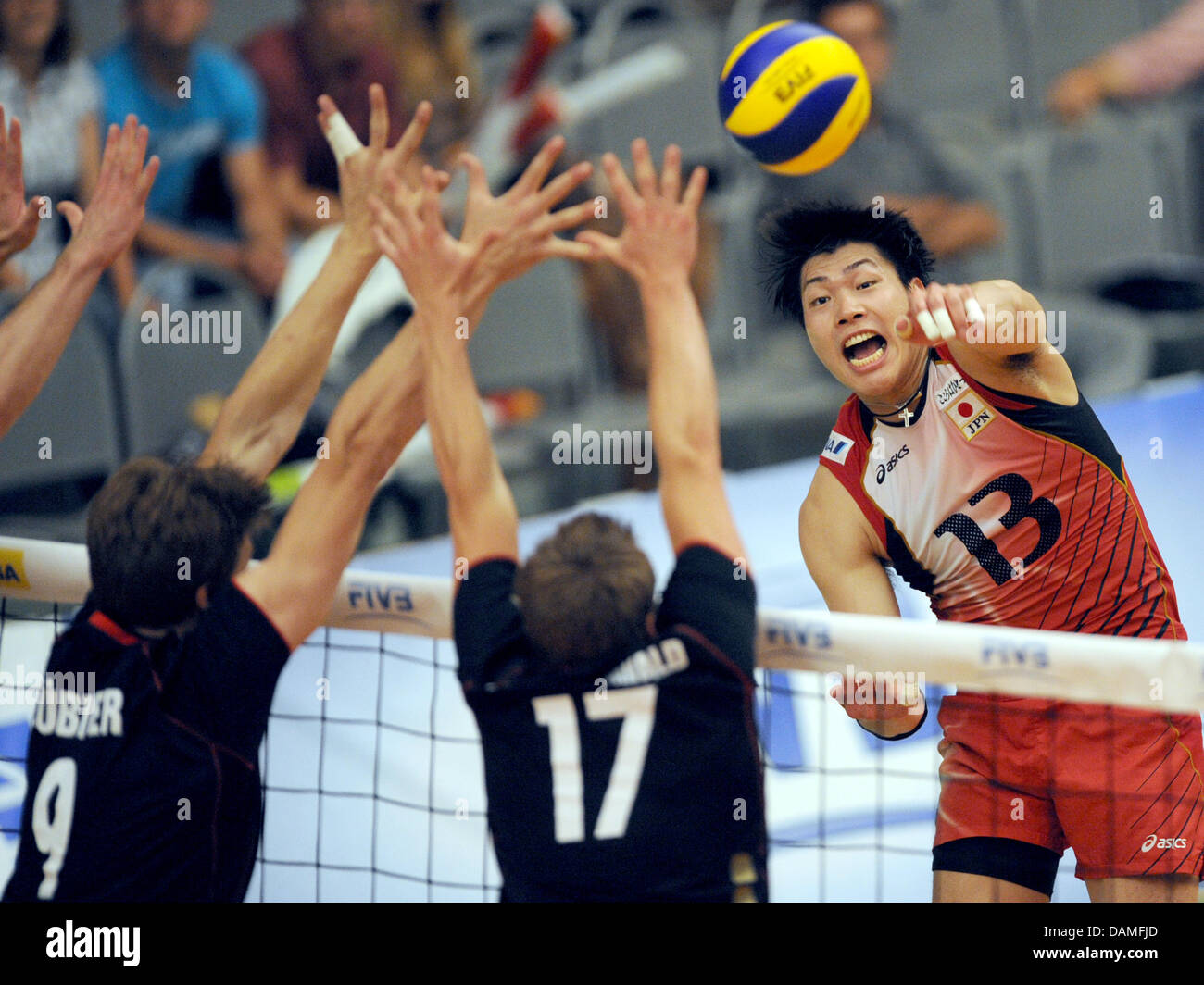 Japan's Kunihiro Shimizu dashes the ball across the net against Germany ...