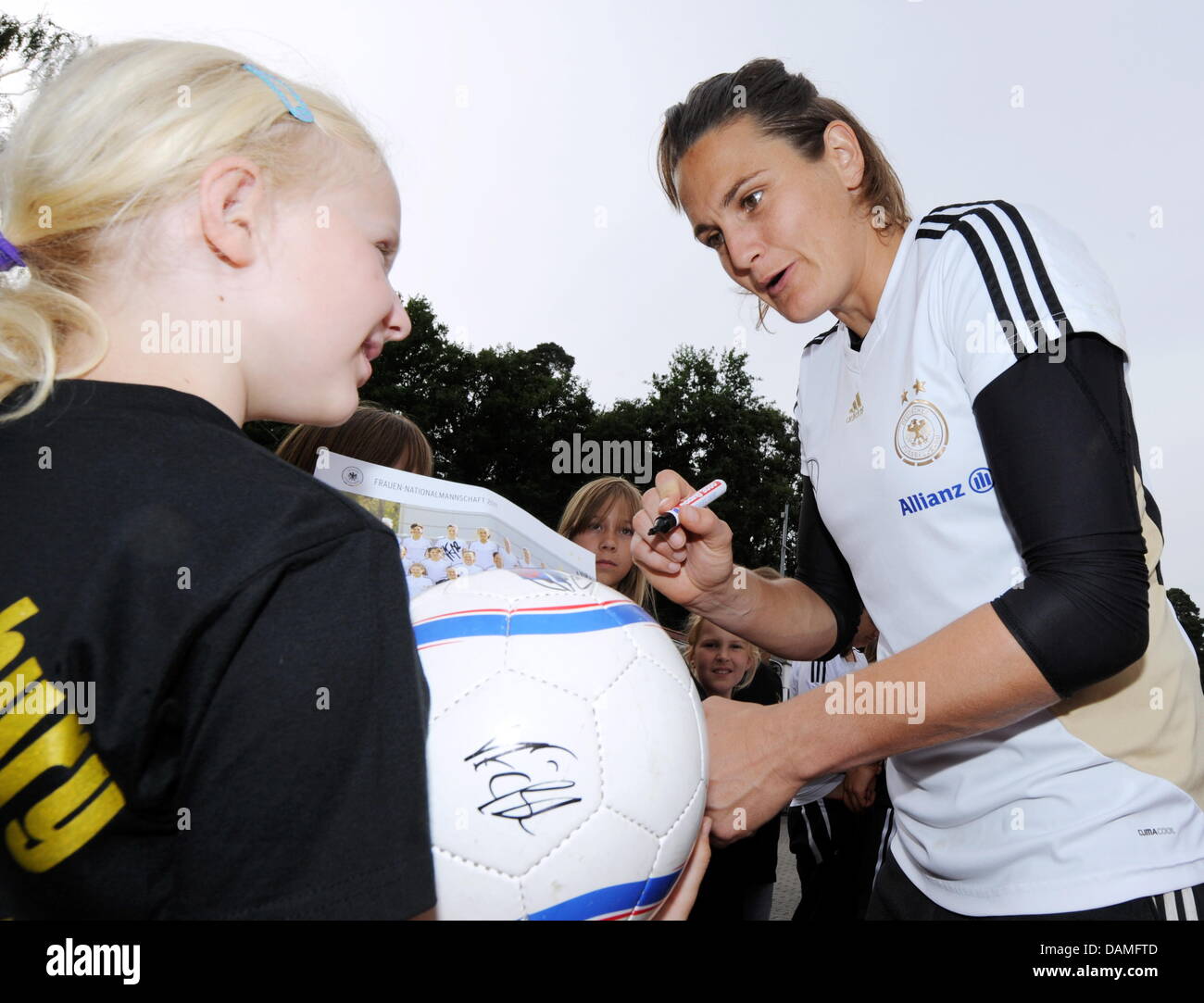 The German national keeper Nadine Angerer (R) signs an autograph for ...