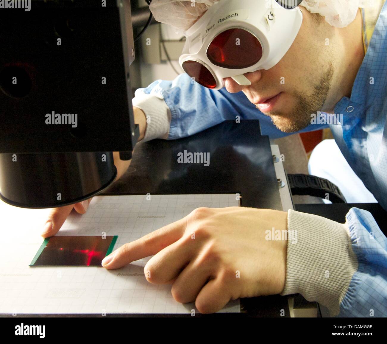 Engineer Yves Rausch places an assay in a laser processing machine at ...
