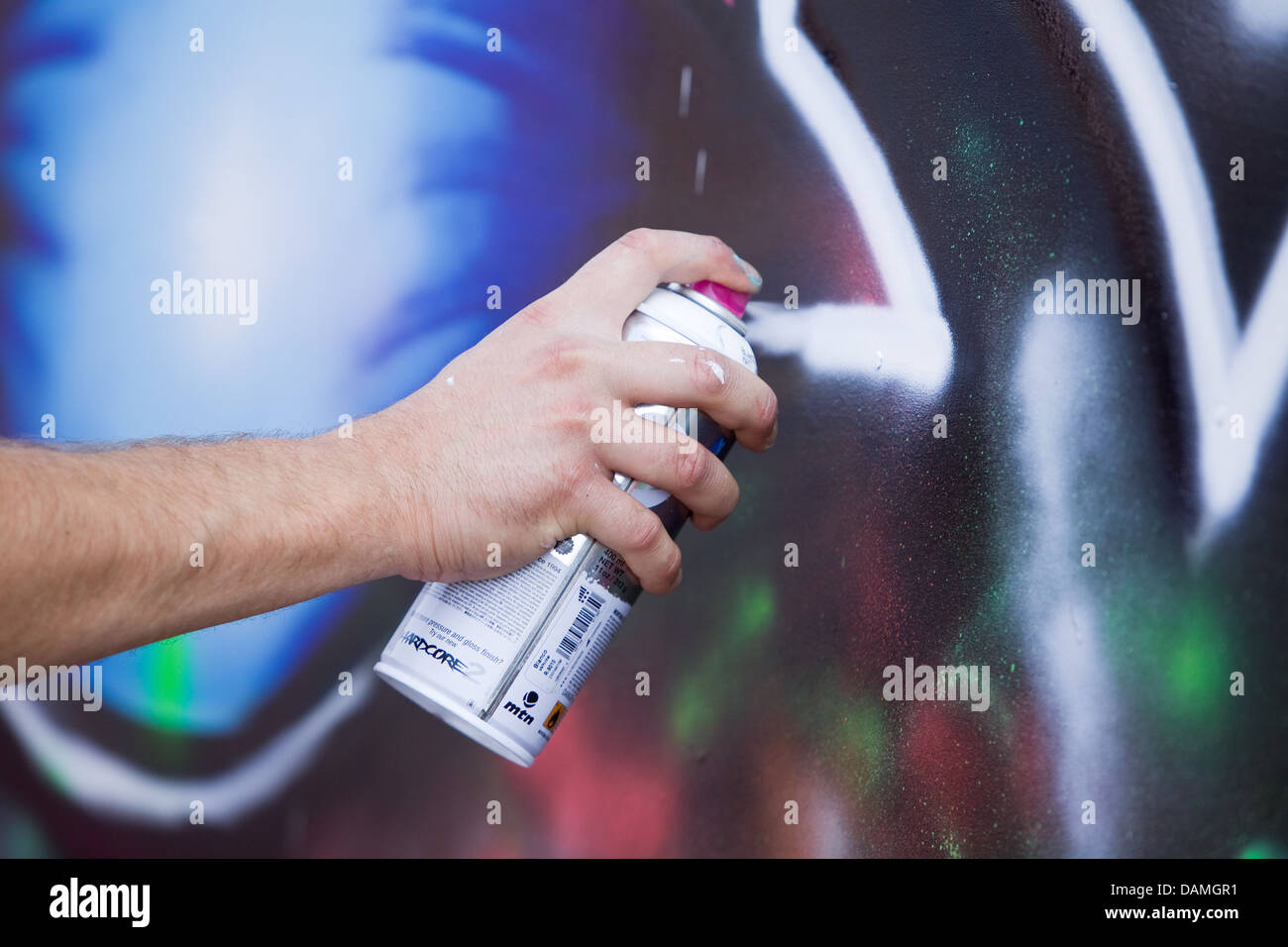 A close up photograph of a graffiti artist holding an aerosol can of ...