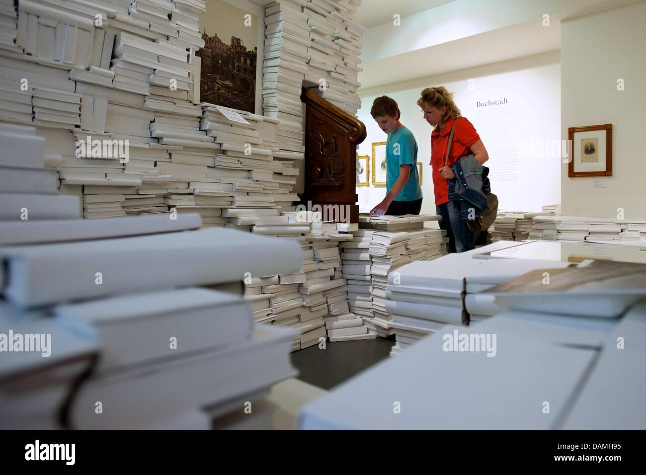 Two visitors walk through the section 'Messestadt' (lit. trade fair ...