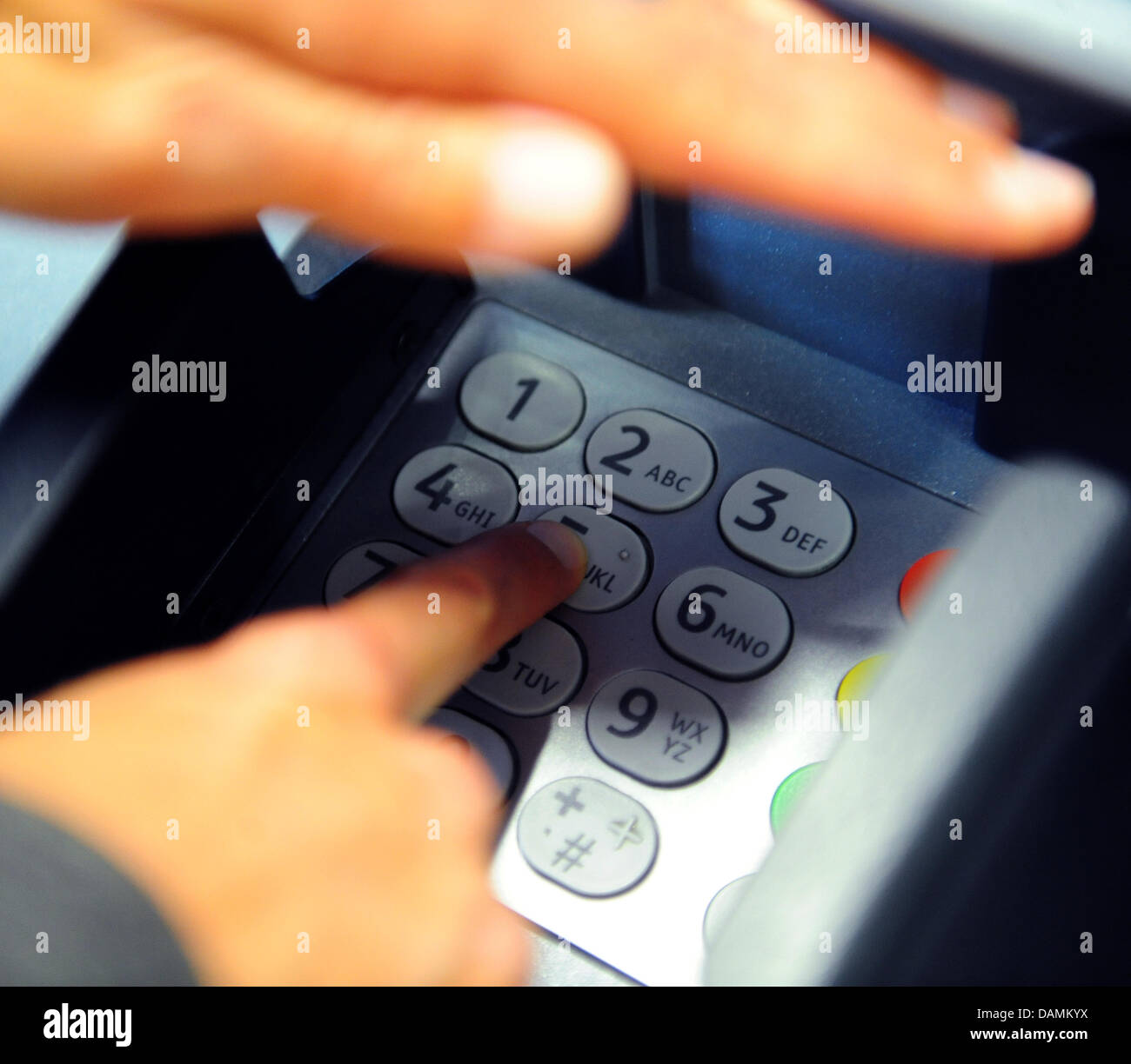 A woman covers the console of a cash dispenser in Munich, Germany, 20 ...