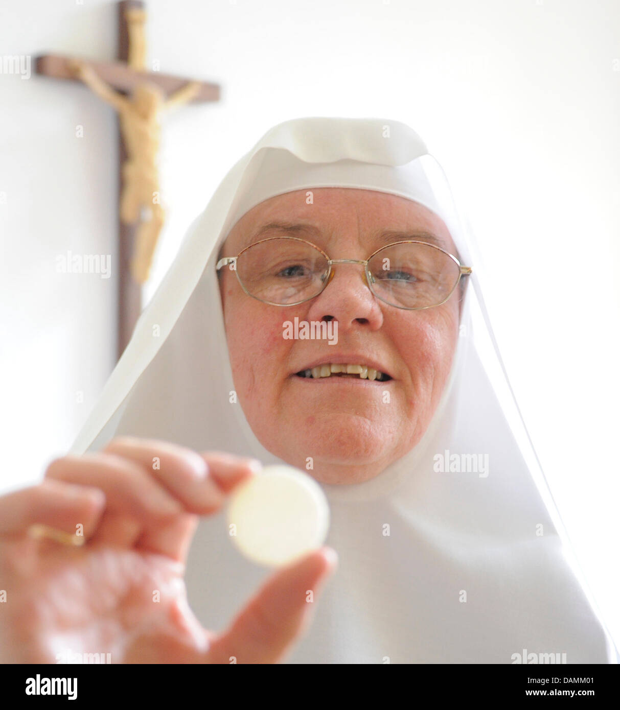 Sister Theresia holds a piece of sacramental bread at the Benedictine ...