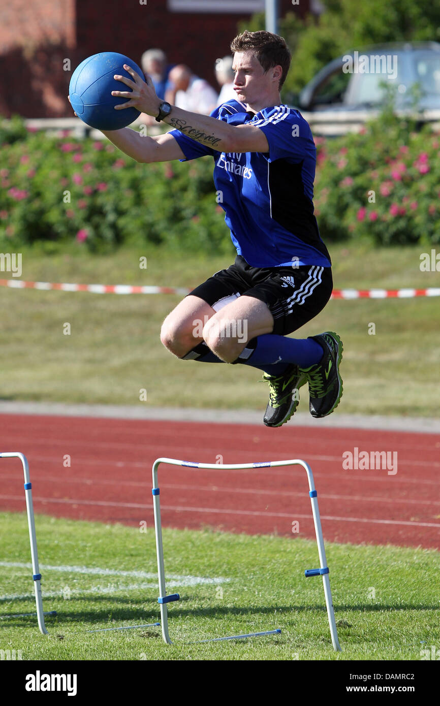 Hamburger SV player Marcell Jansen jumps with a medicine ball during a ...