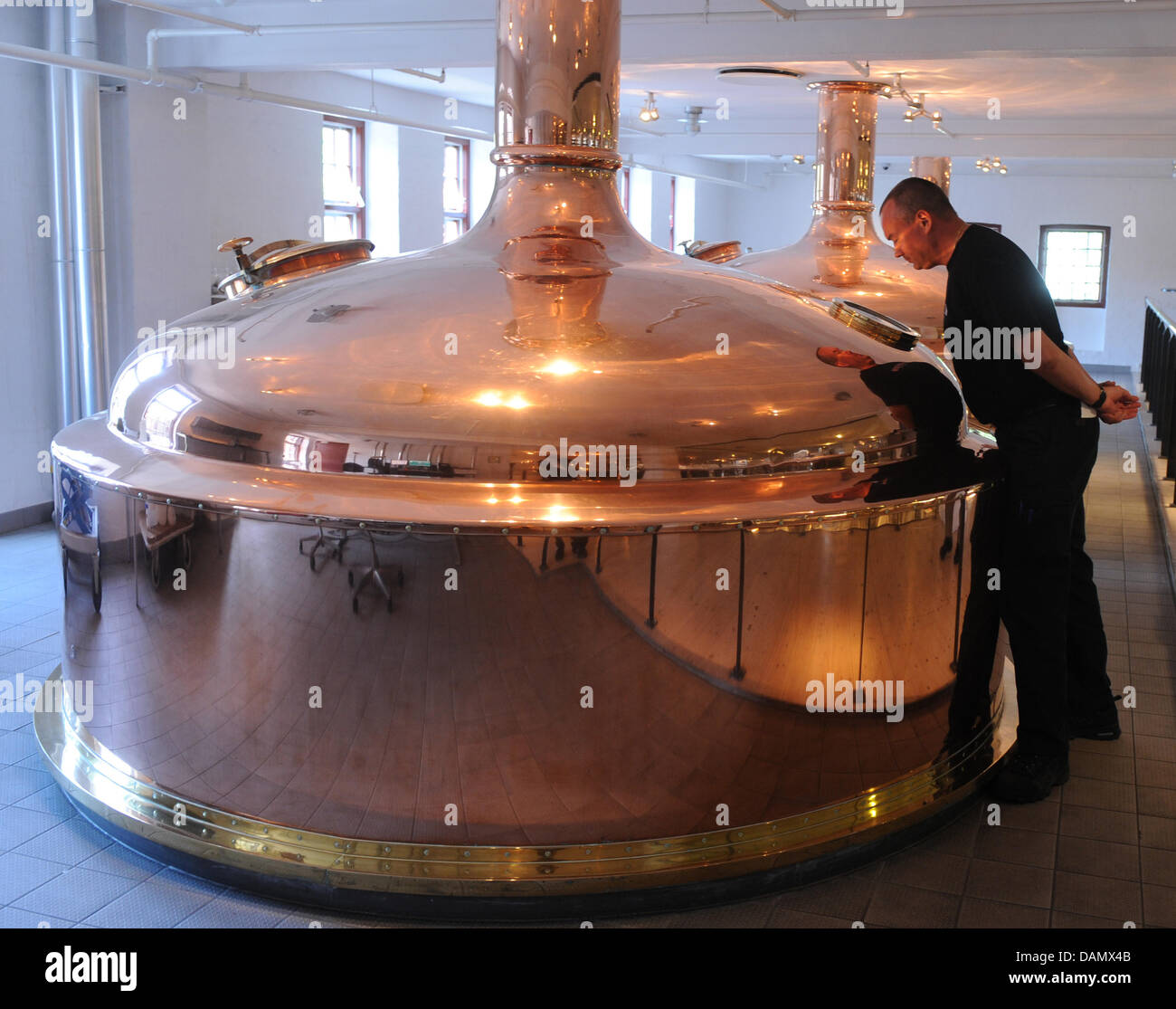 A member of staff monitors a brew kettle for beer on the brewery ...