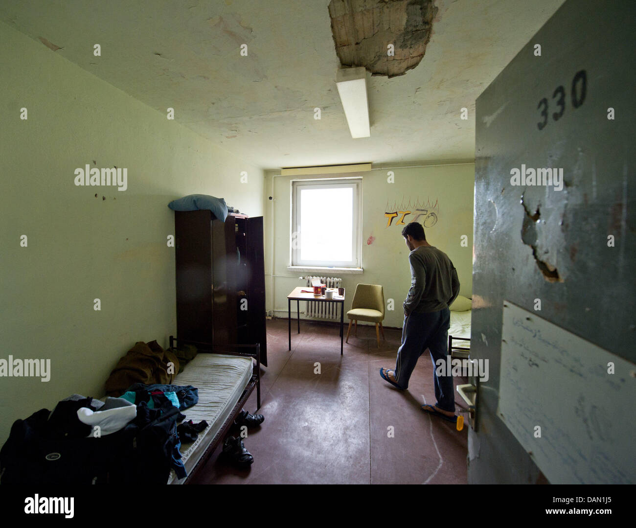 An asylum seekers sits in a room of a residence of the immigration ...