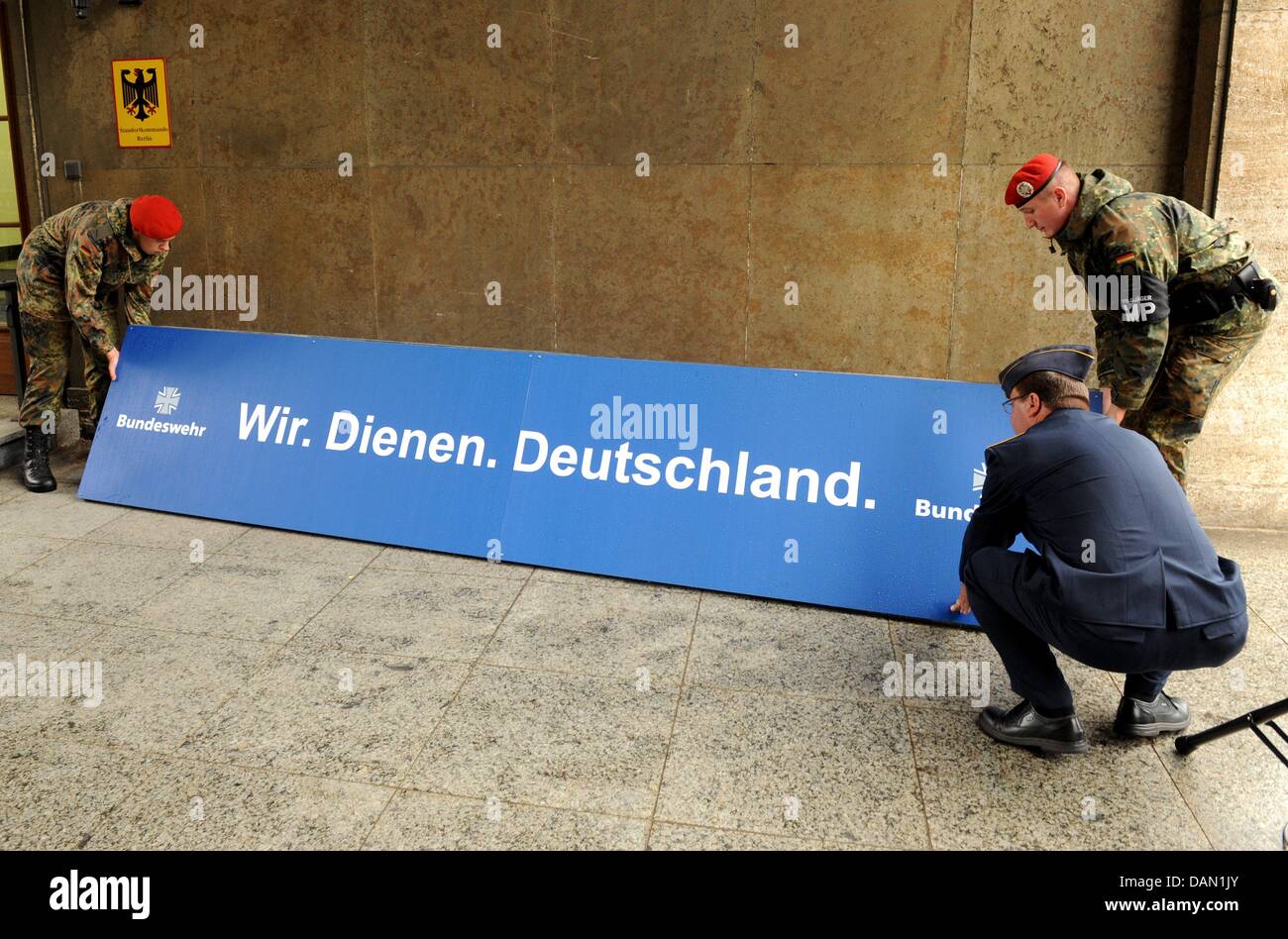 Soldiers set up a sign with the new motto of the German Armed Forces at ...