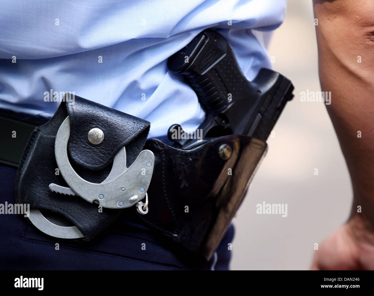 A policeman wears handcuffs and a weapon during a visit to the ...