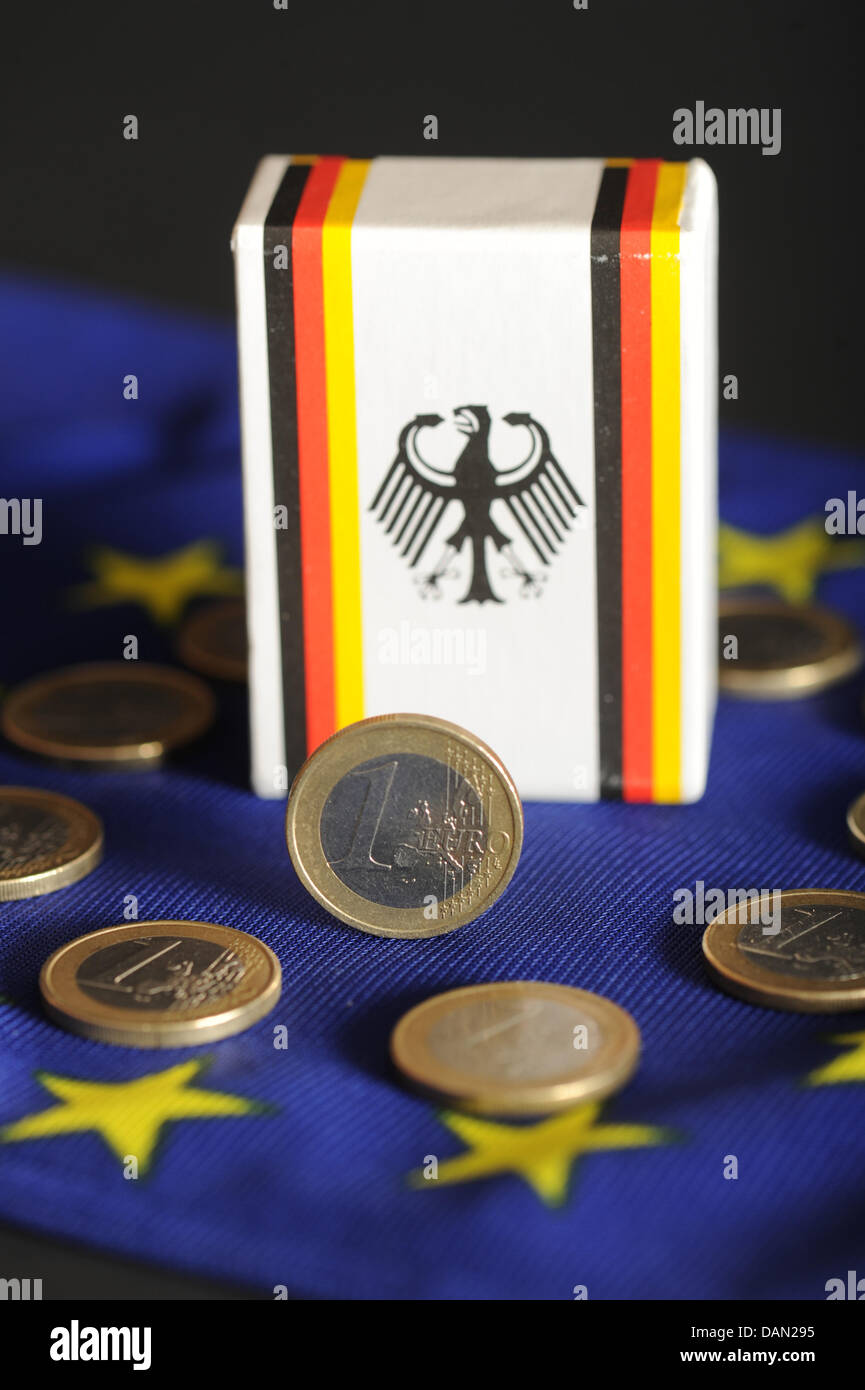 Euro coins and a miniature German constitution lie on a European flag ...