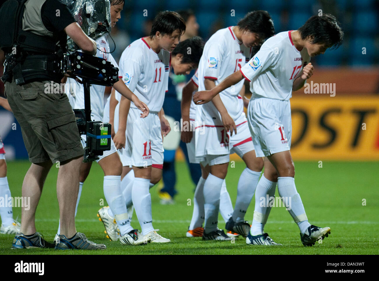 Ri Ye Gyong, Yu Jong Hui and Ri Un Hyang of North Korea leave the pitch ...