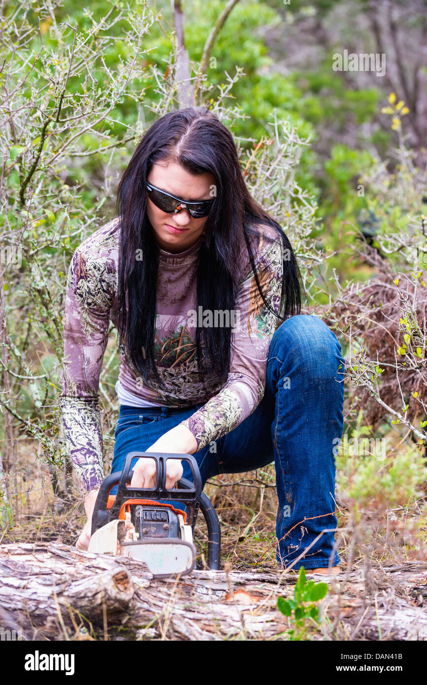Young woman cutting log with chainsaw hi-res stock photography and ...