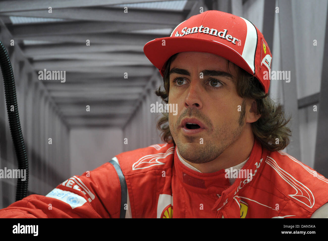 Spanish Formula One driver Fernando Alonso of Ferrari creases his face ...