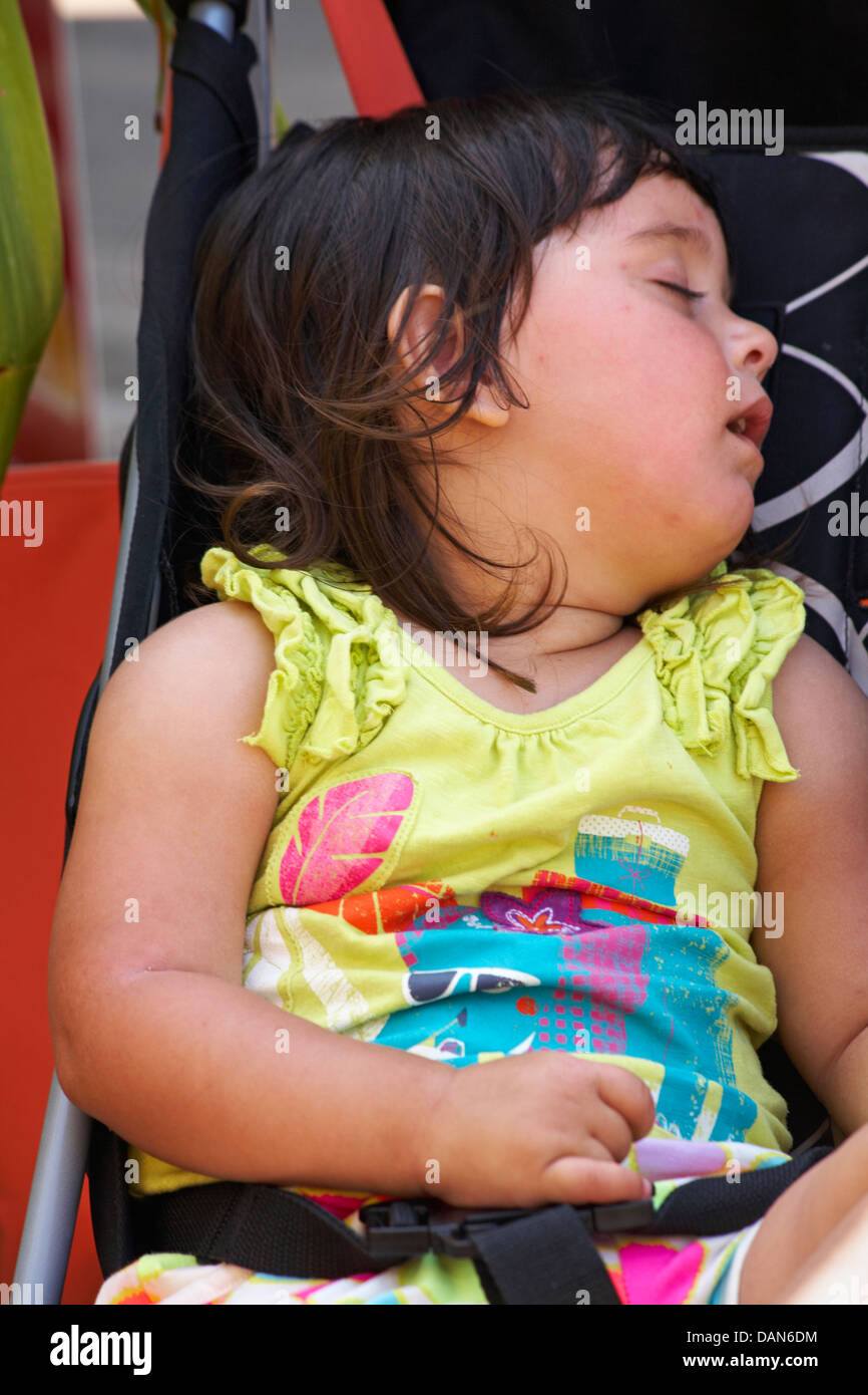 Tired young girl asleep in pushchair Stock Photo - Alamy