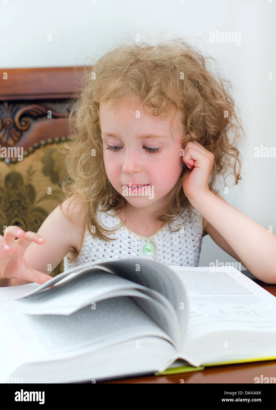 Cute little girl reading a book Stock Photo - Alamy
