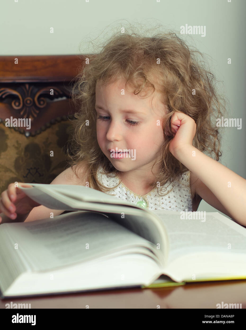 Cute little girl reading a book Stock Photo - Alamy