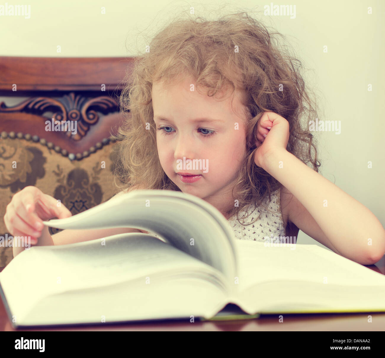 Cute little girl reading a book Stock Photo - Alamy