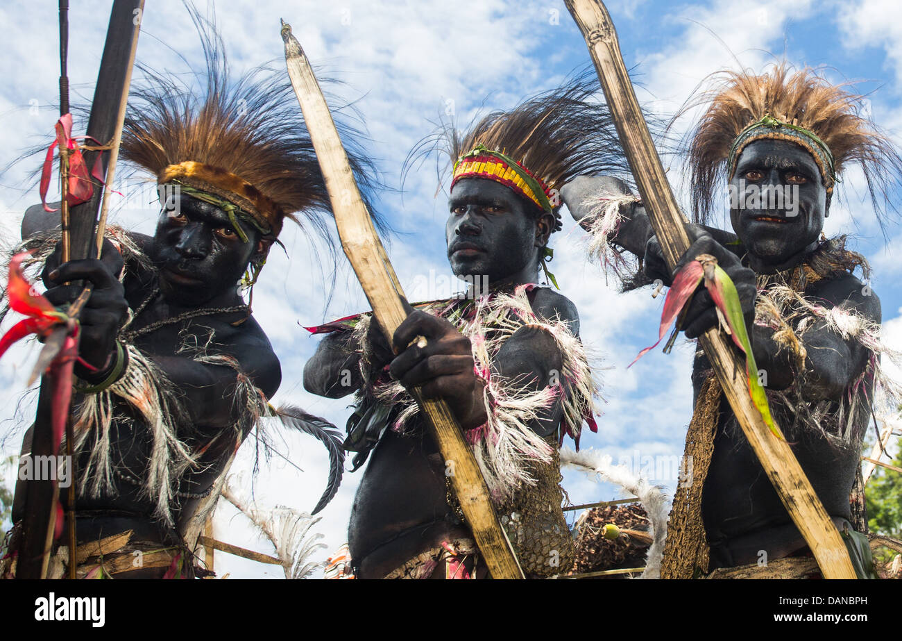 Looking up at a group of tribal warriors with drawn bow and arrows ...