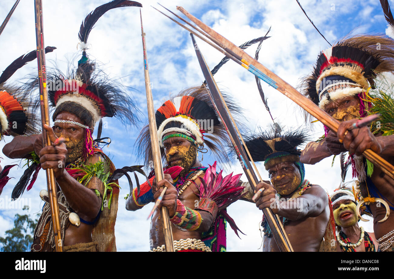 Looking up at a group of tribal warriors with drawn bow and arrows ...