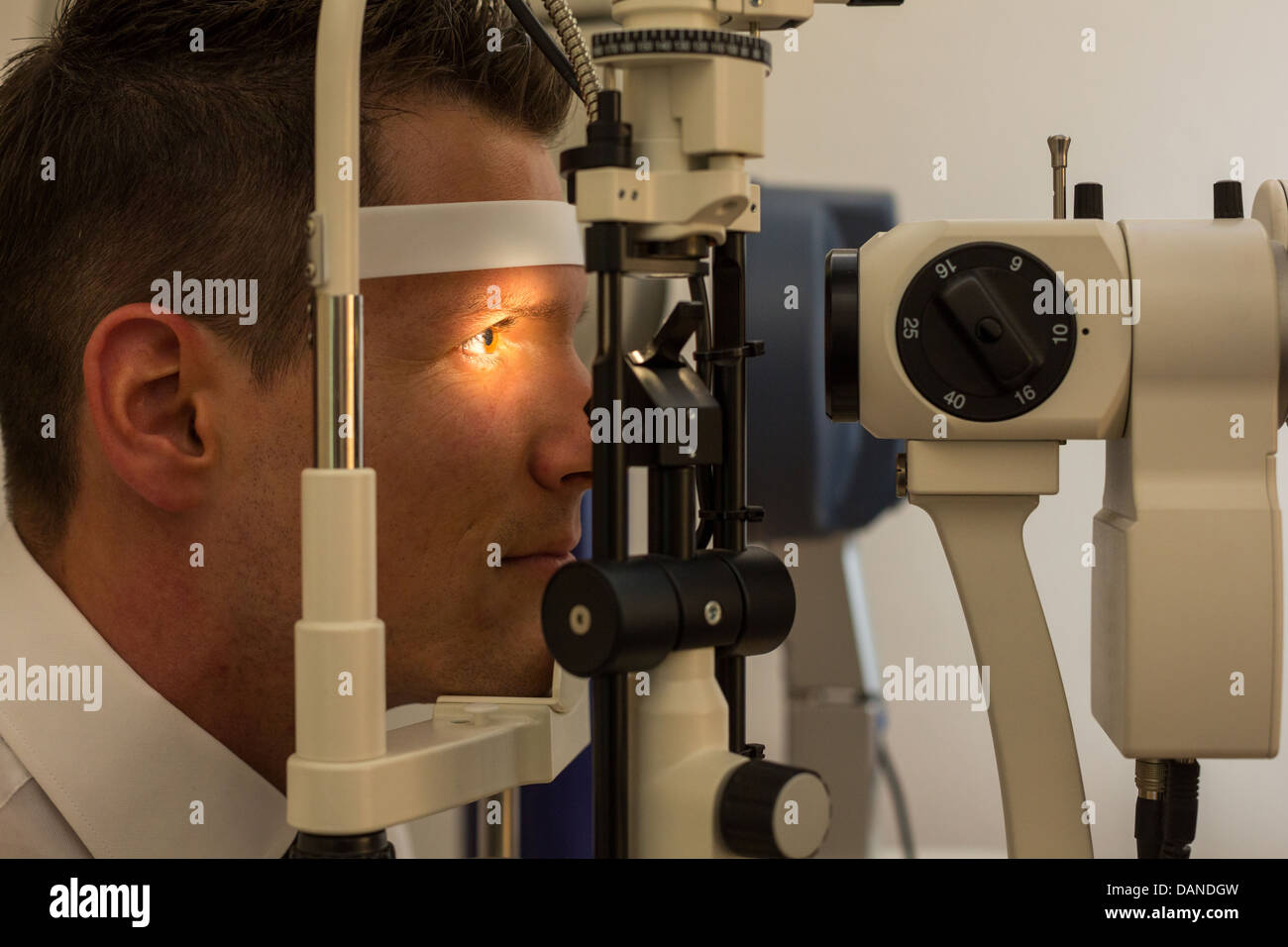 Patient or customer at slit lamp at optometrist or optician Stock Photo ...