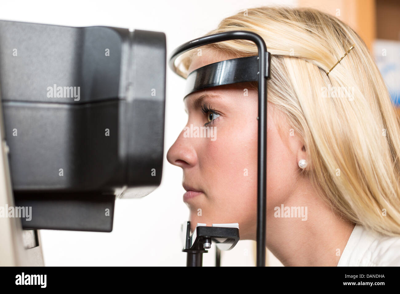 Patient and auto refractometer at optician or optometrist for scanning ...