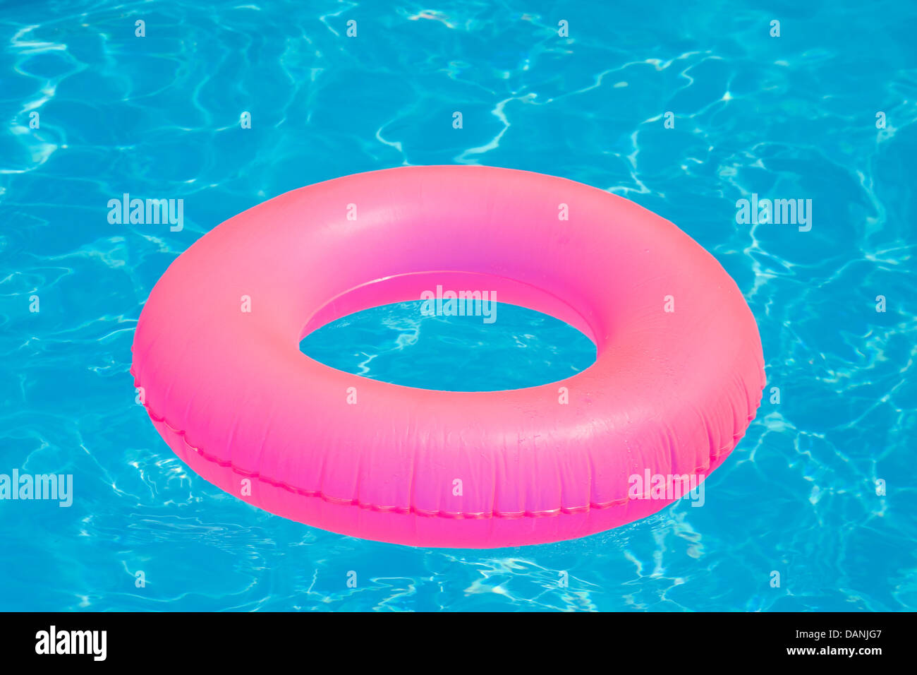 Colorful inflatable ball and round tube floating in swimming pool Stock ...
