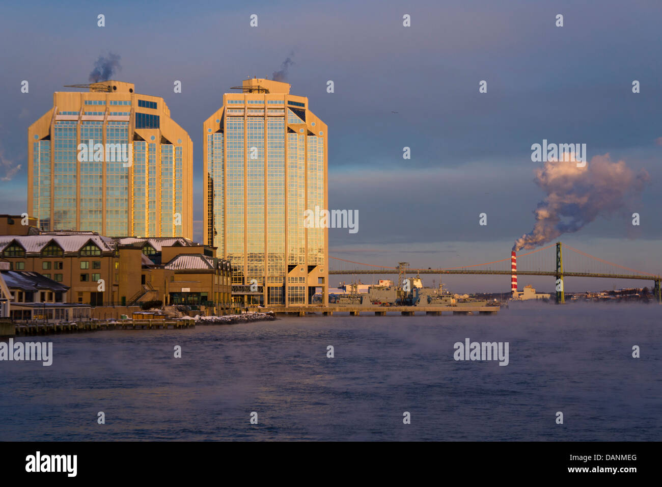 Sunrise illuminates the skyline of the waterfront and light sea smoke ...