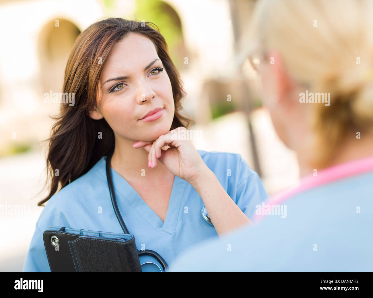 Two Young Adult Professional Female Doctors or Nurses Talking Outside ...