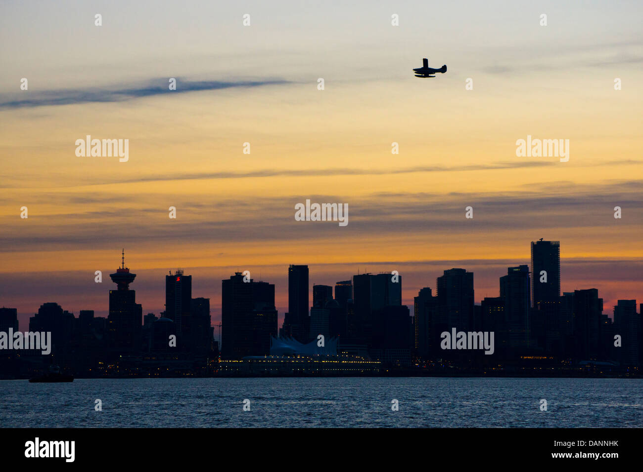 Float plane flying over Vancouver skyline at sunset Stock Photo - Alamy