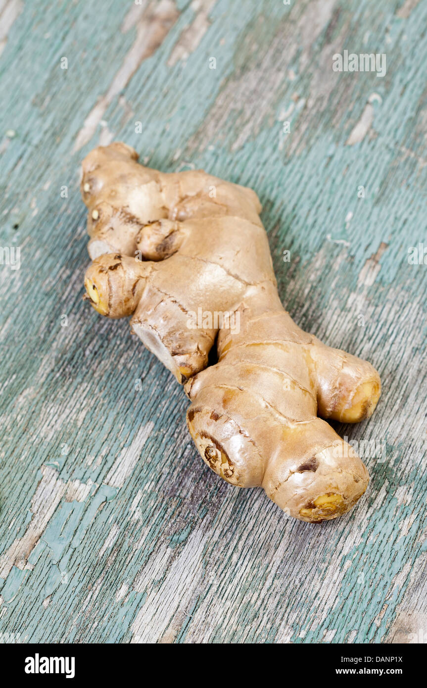 A fresh ginger root on a cracked painted wood surface Stock Photo - Alamy