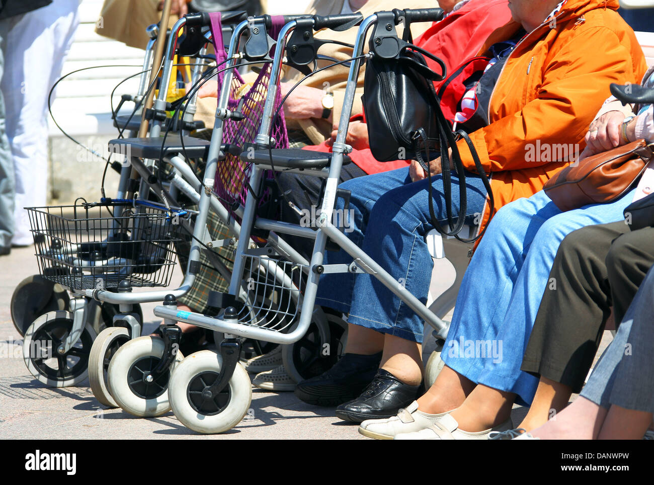Wheeled walkers, so-called 'rollators', are parked in front of seniors ...
