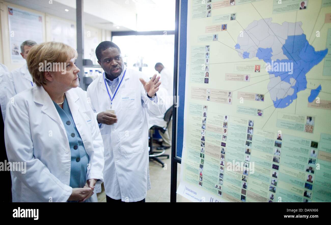 German Chancellor Angela Merkel listens to a scientist during a visit ...
