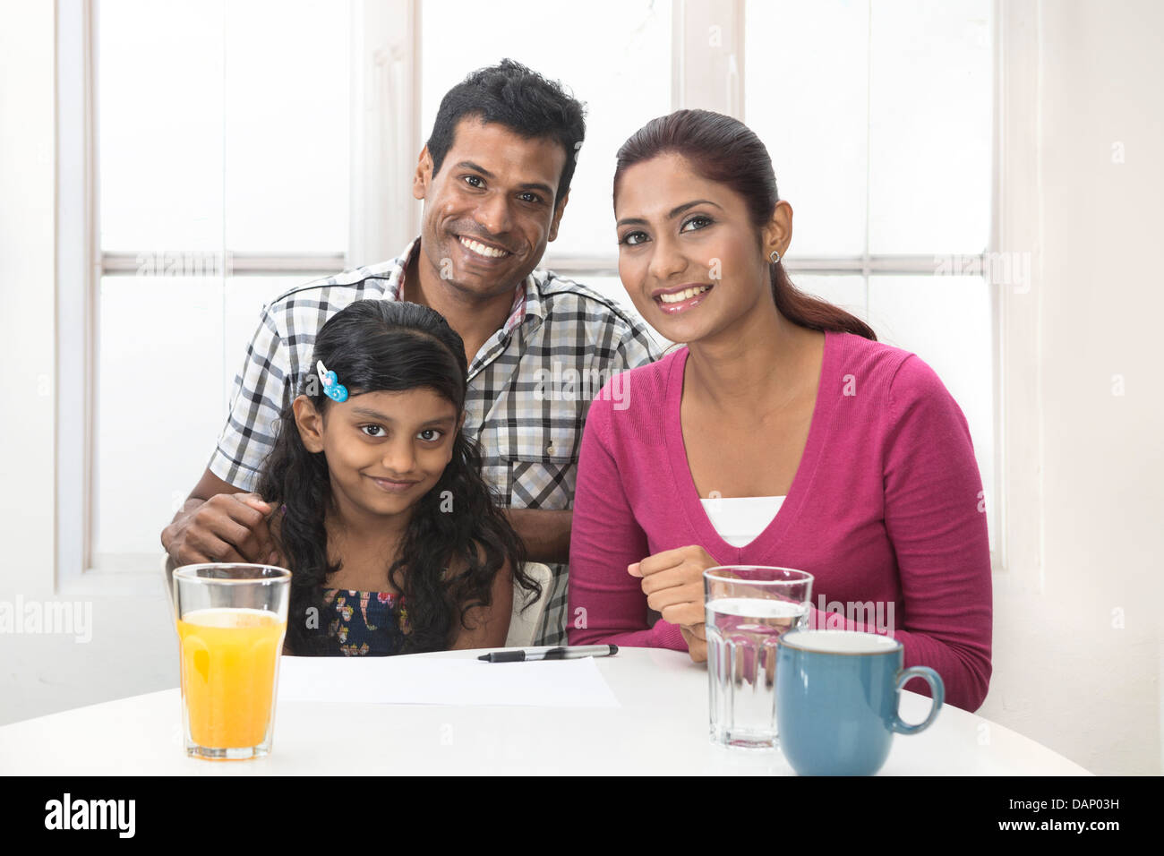Indian parents helping their child with her home work. Indian family in ...