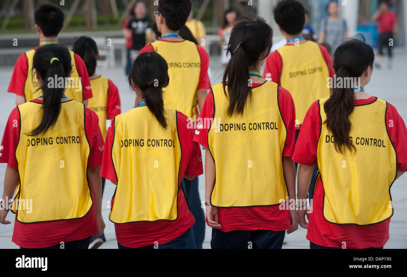 Volunteers, wearing vest with the label "doping control" on their way ...