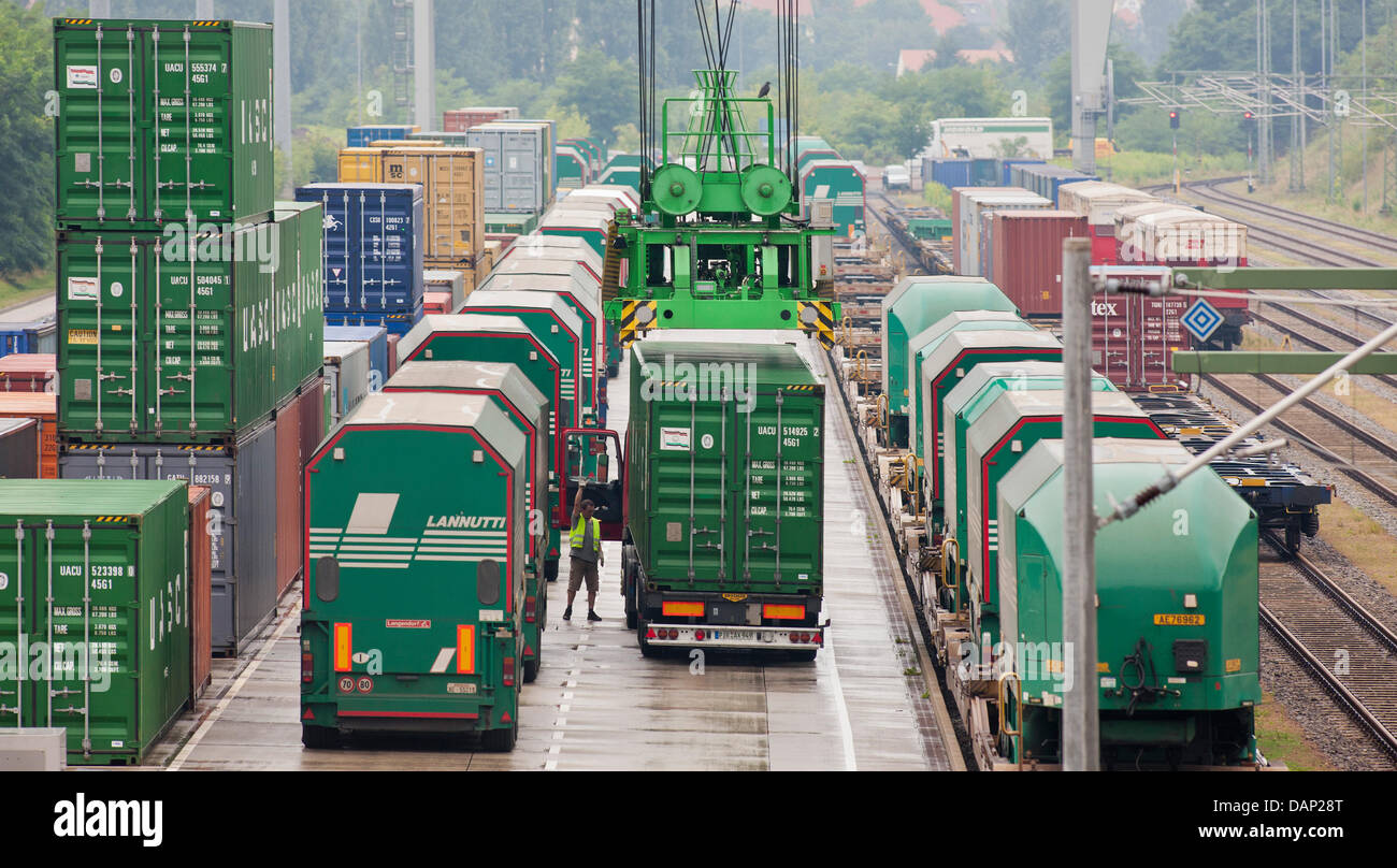 A load crane loads a container onto a lorry at the freight service ...