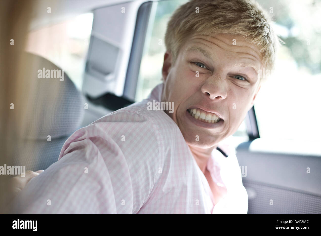 Germany, Duesseldorf, Young man making angry face in car Stock Photo ...