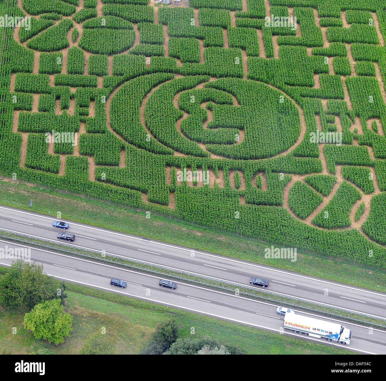 Lorries drive past a labyrinth created in a corn field at the A8 ...