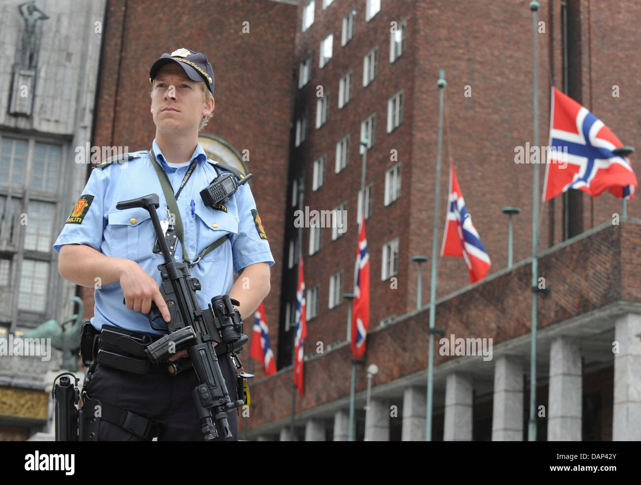 AN Armed police officer standS in front of the town hall of Oslo ...