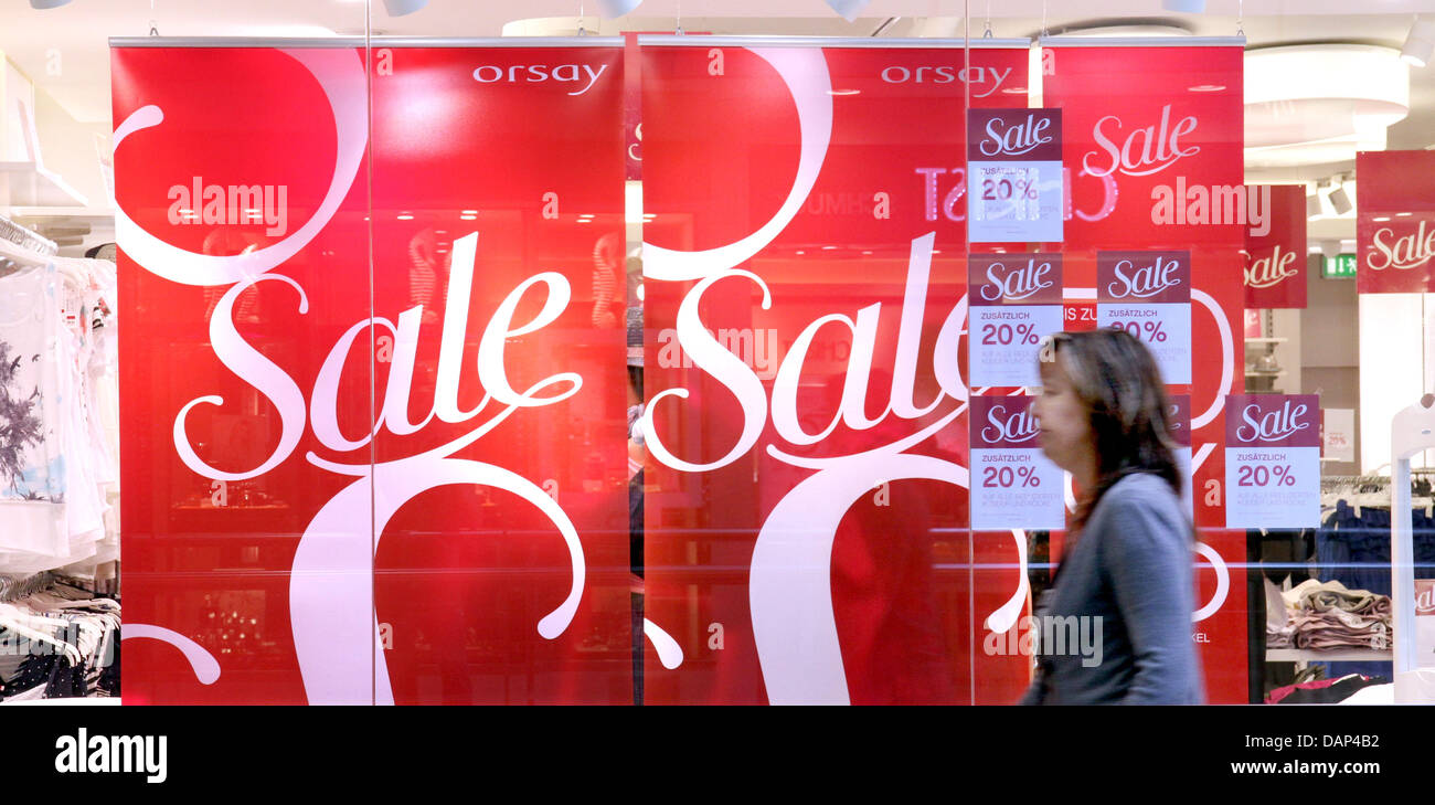 A woman stands in front of a showcase of a department store, that ...