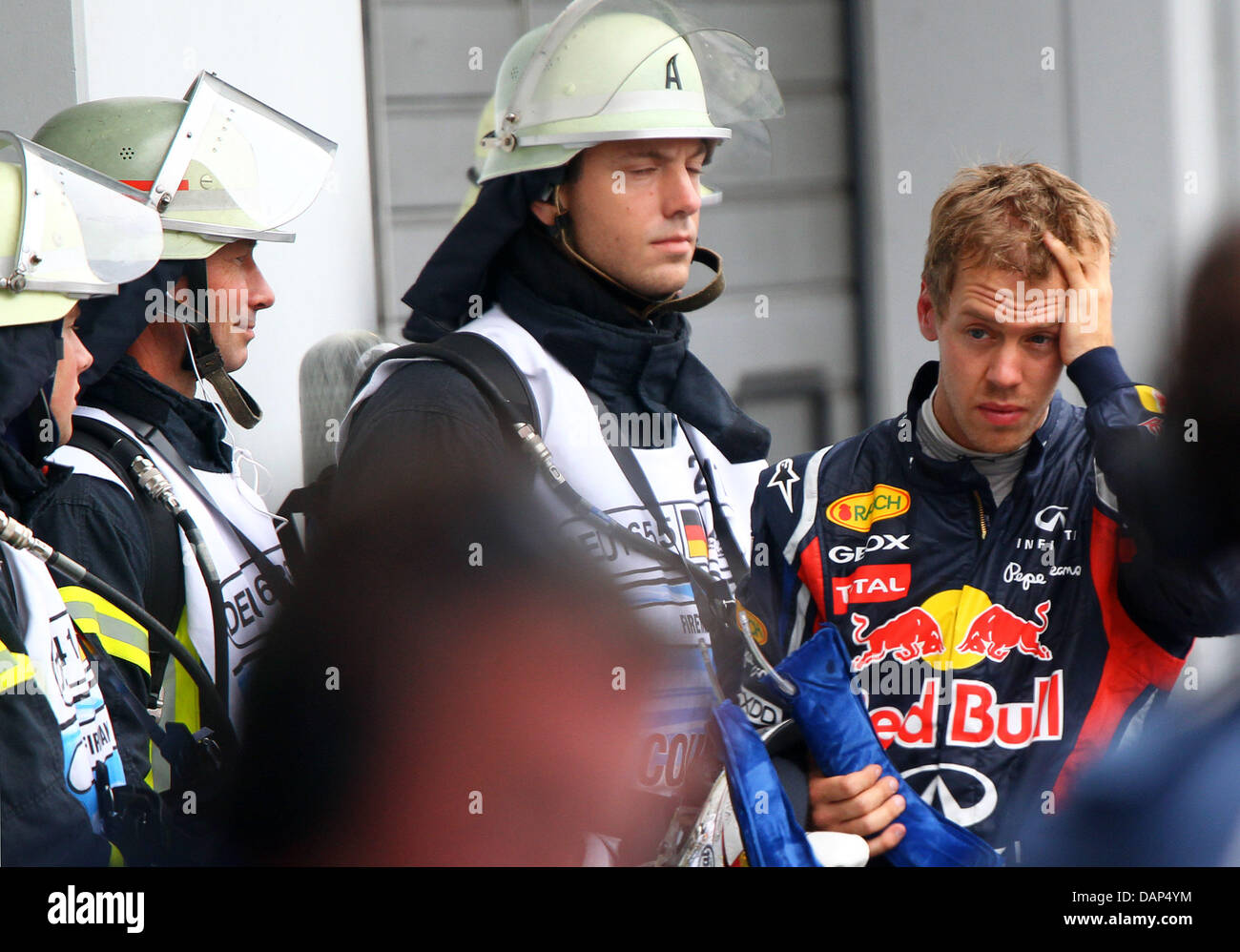 German Formula One driver Sebastian Vettel (R) of Red Bull reacts after ...