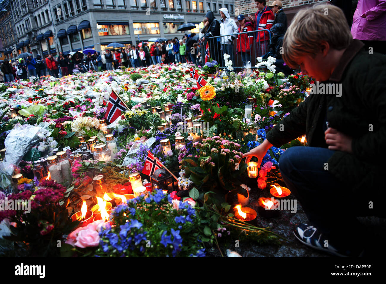 Norwegian flags, flowers and candles are seen at the ground in front of ...