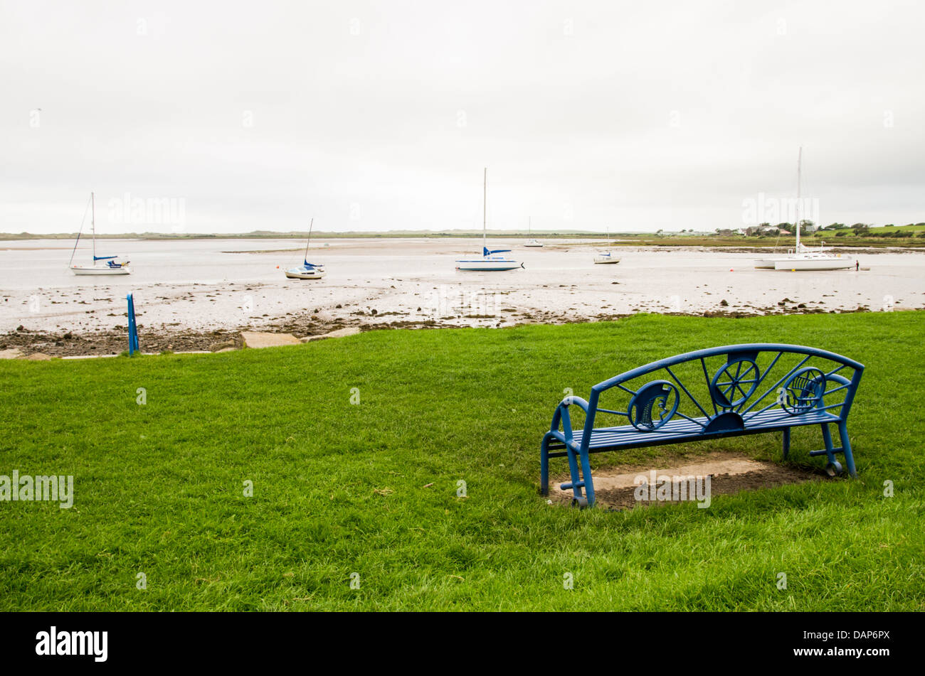An empty metal bench on a shore of river Esk during low tide with few ...