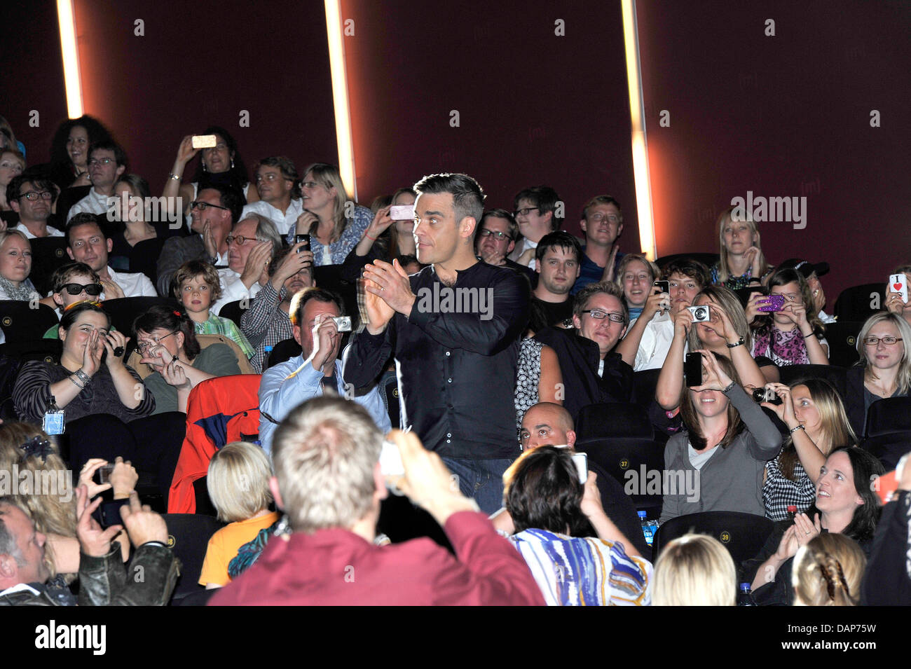 Robbie Williams is surrounded by fans and journalists during the ...