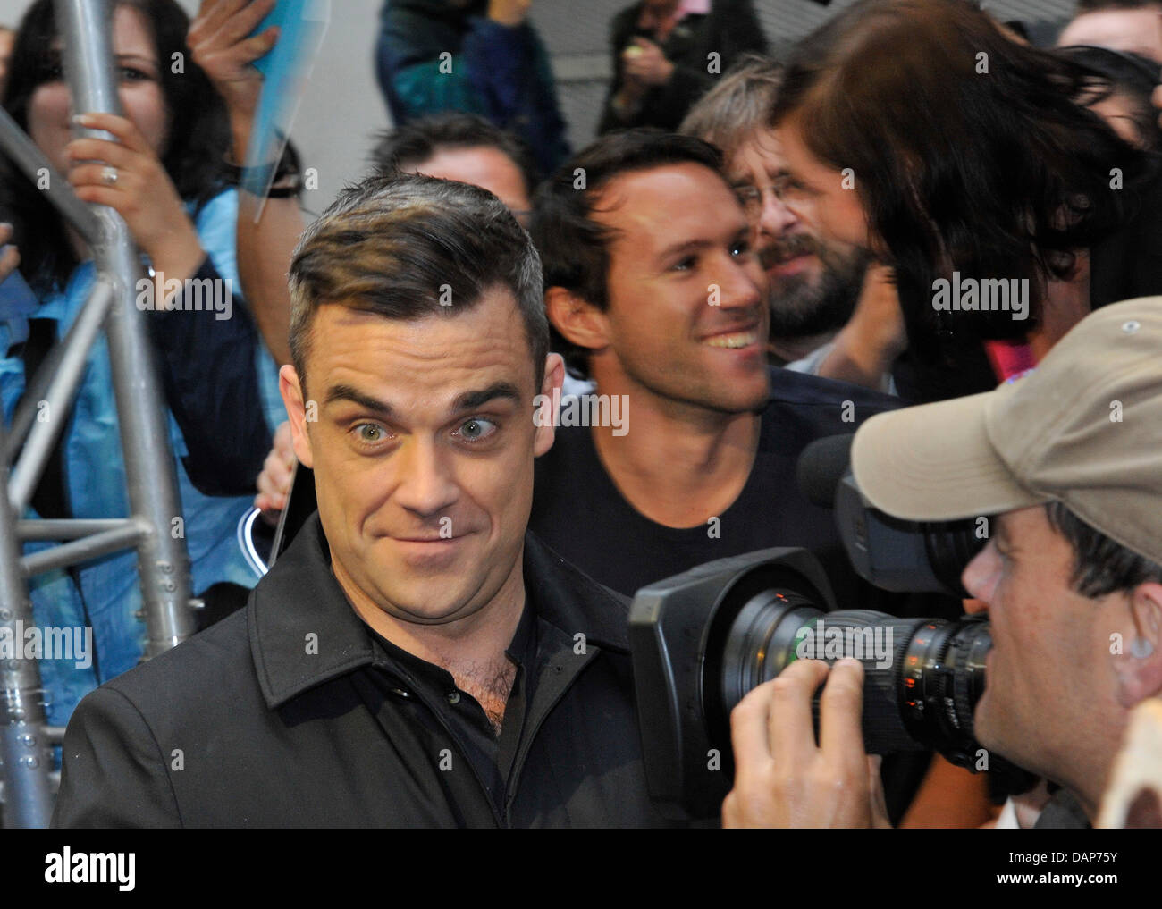 Robbie Williams is surrounded by fans and journalists during the ...