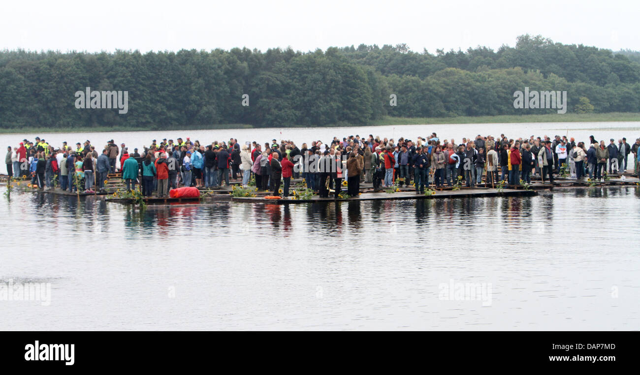 Several hundred people stand on a 1,550 square meter raft made from ...