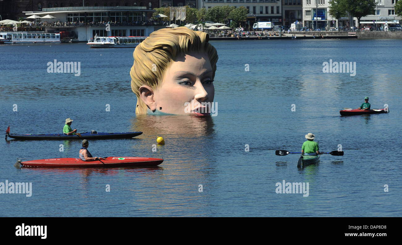 Kayak riders view the giant mermaid at the inner Alster in Hamburg ...