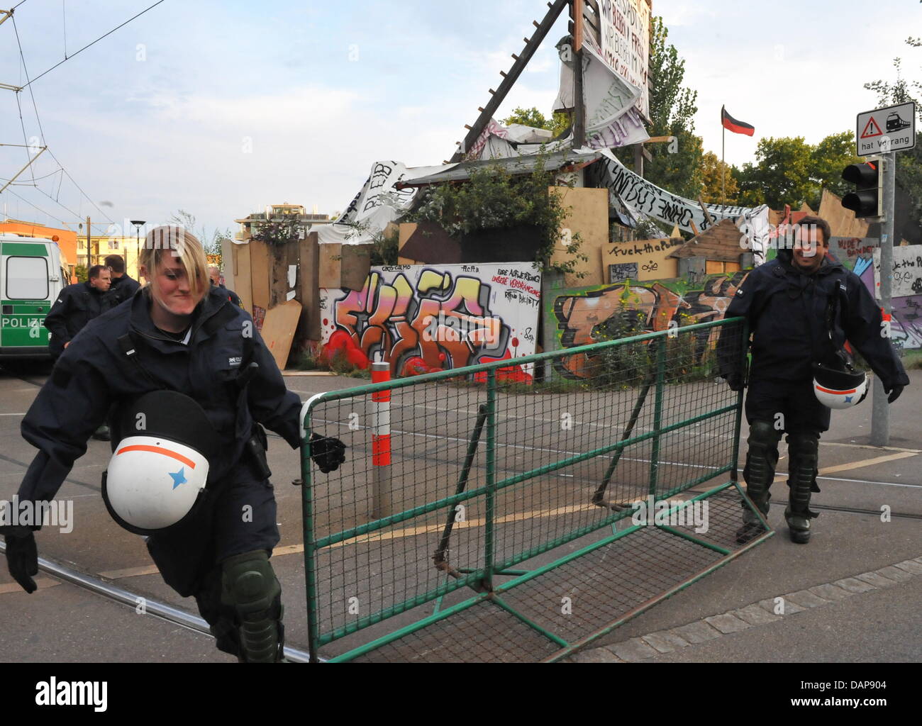 Police officers set up barriers around an occupied building plot in ...